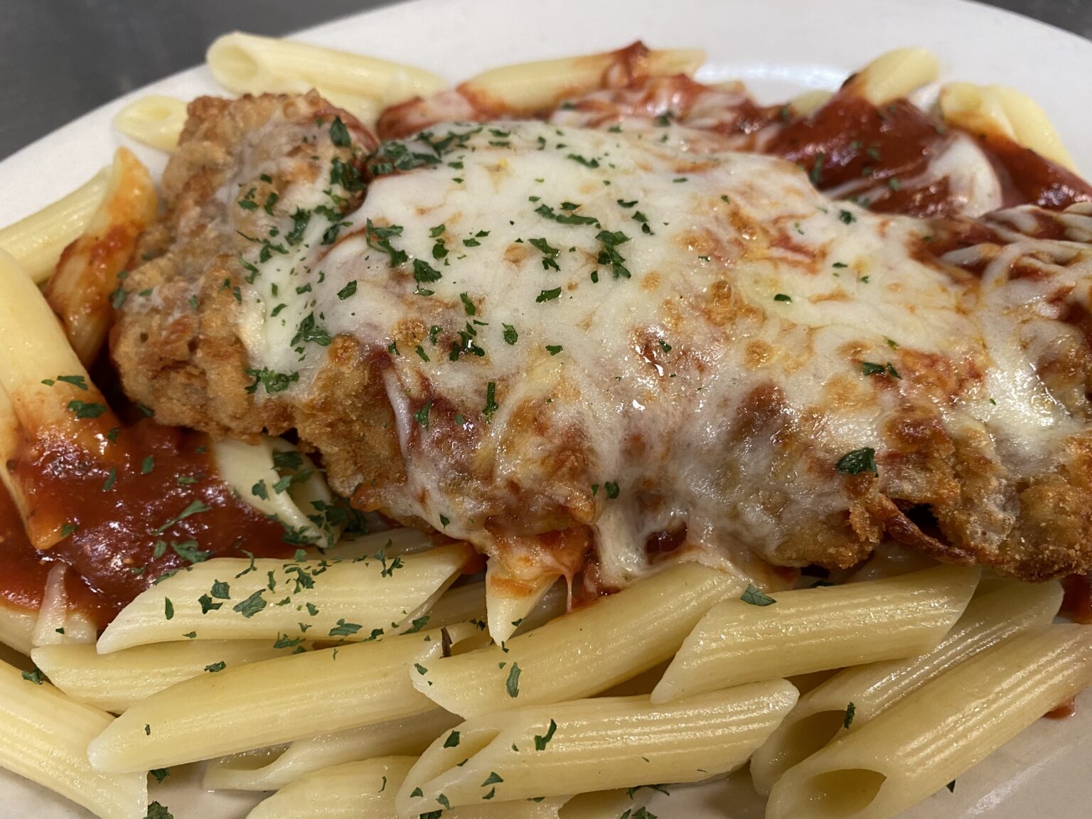 Veal Parmigiana over Pasta - Rockefeller's Grille